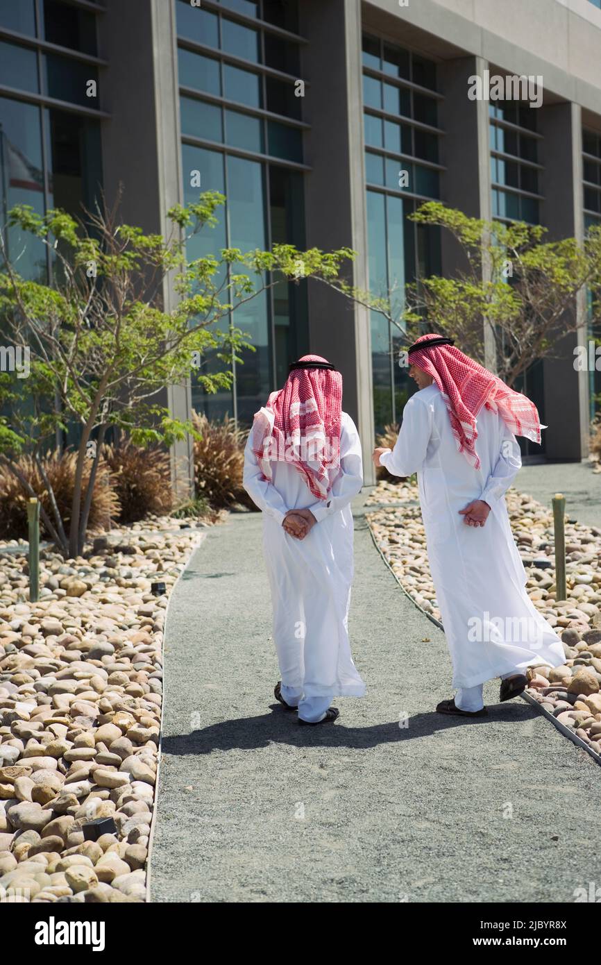 Middle Eastern men in traditional clothing walking on path Stock Photo ...