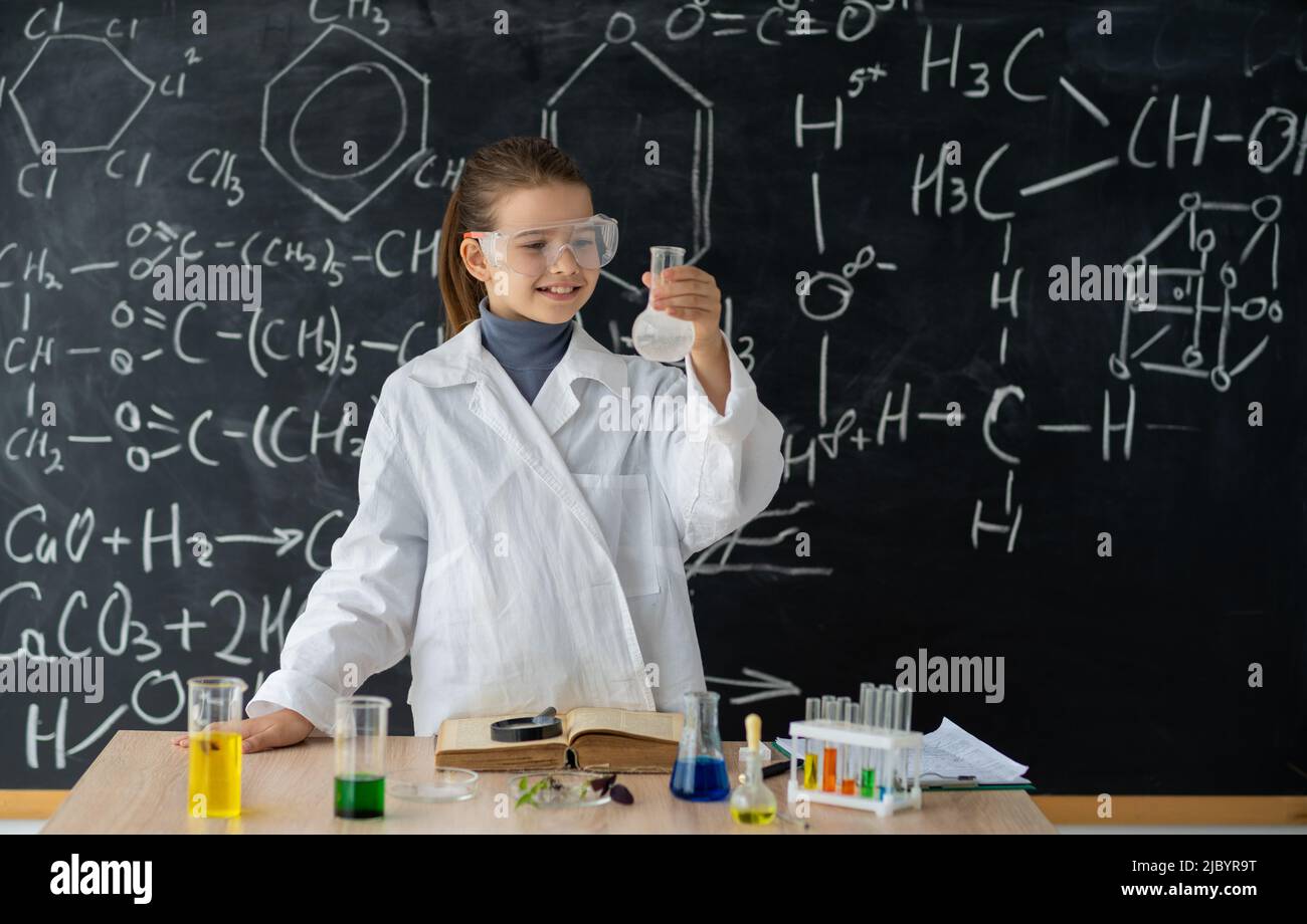 Experiments in a chemistry lab. serious little student conducting an ...