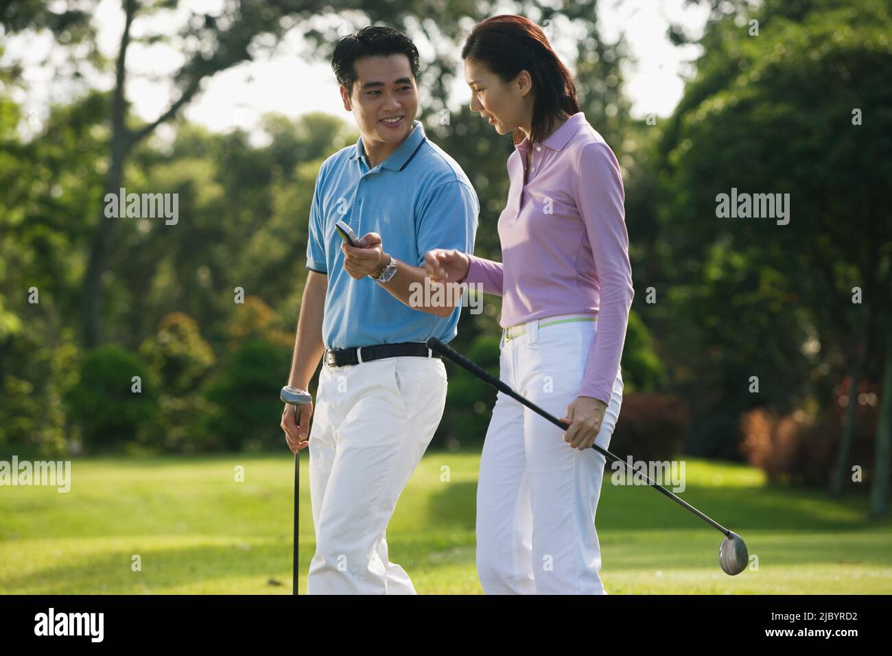 Chinese couple playing golf Stock Photo - Alamy