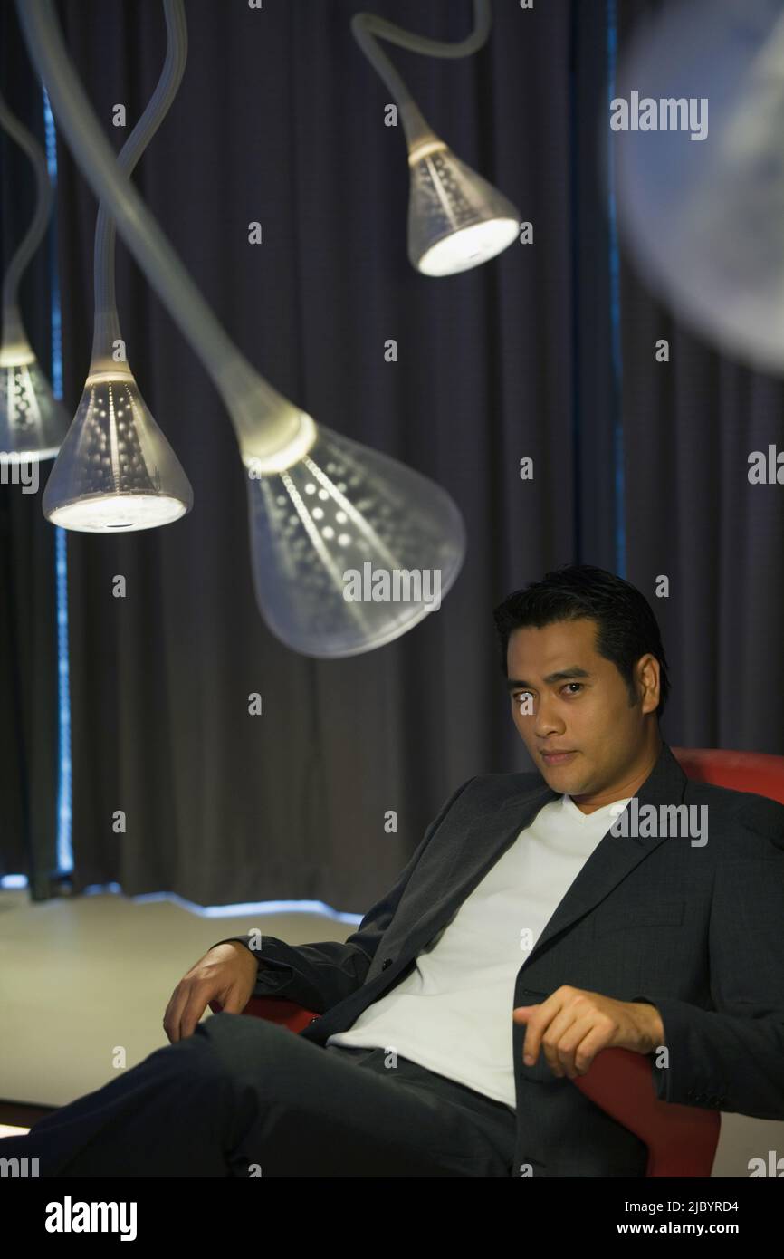 Chinese man sitting in modern living room Stock Photo - Alamy