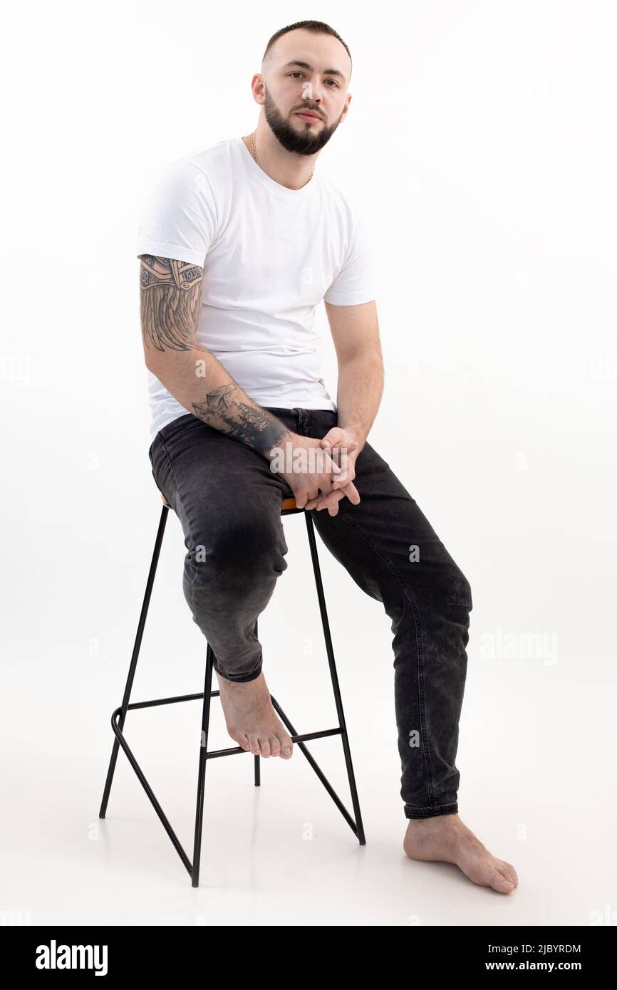 Vertical of tattooed handsome dark-haired, confident, bearded barefoot ...