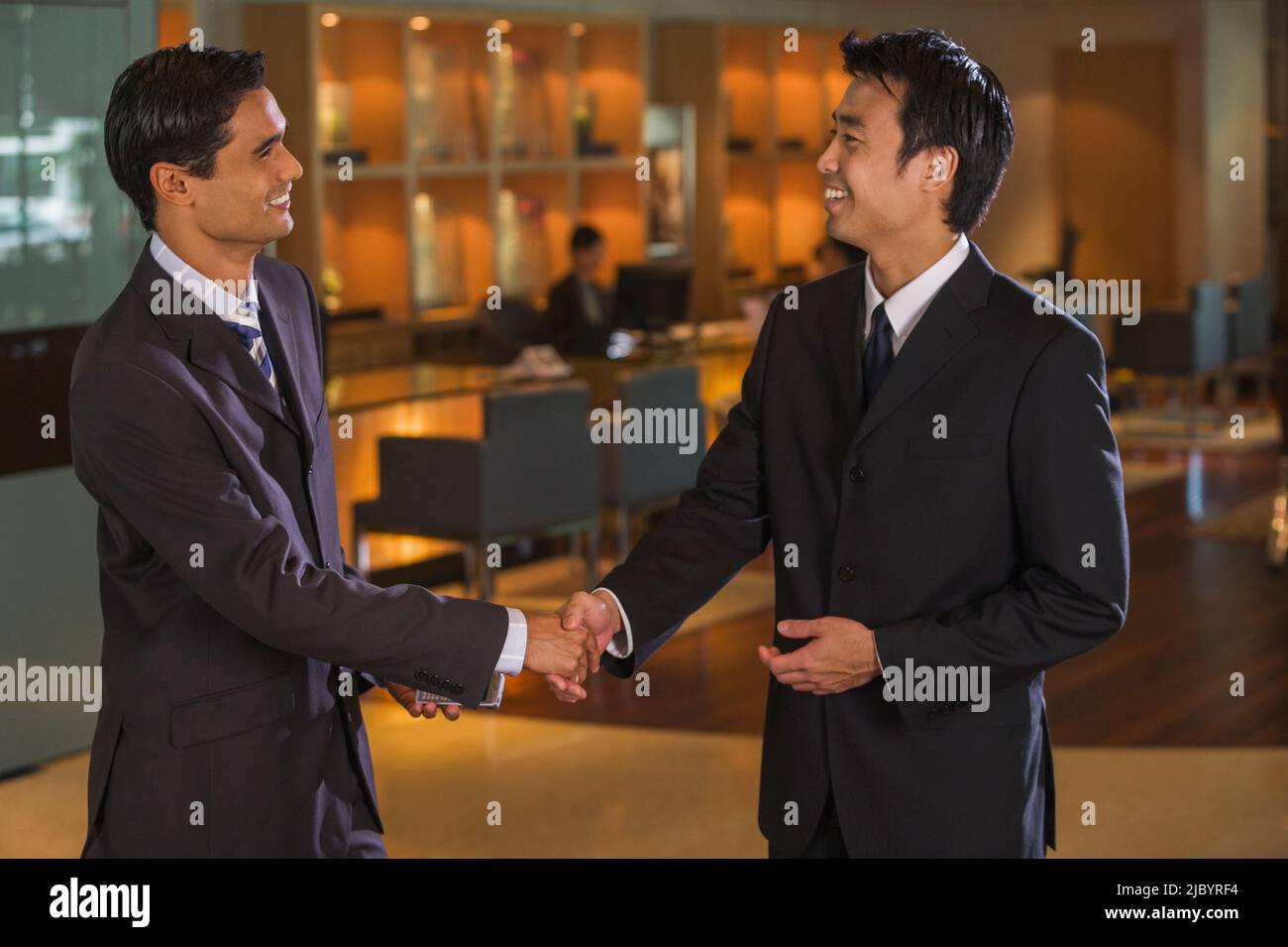 Businessmen shaking hands in bar Stock Photo - Alamy