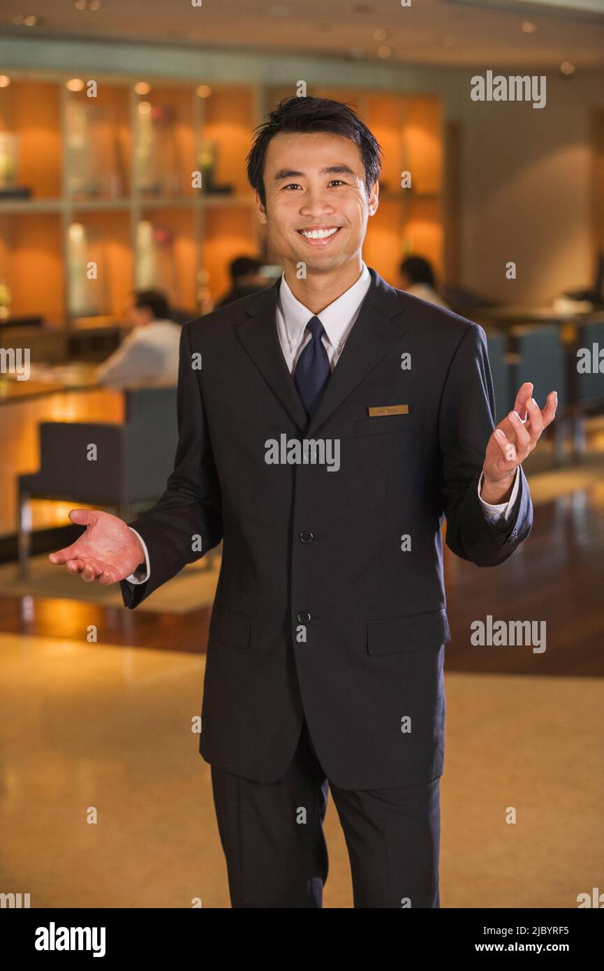 Chinese businessman welcoming guests to bar Stock Photo - Alamy