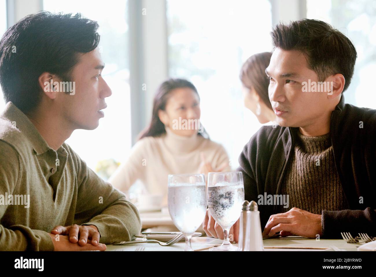 Asian men talking in restaurant Stock Photo - Alamy