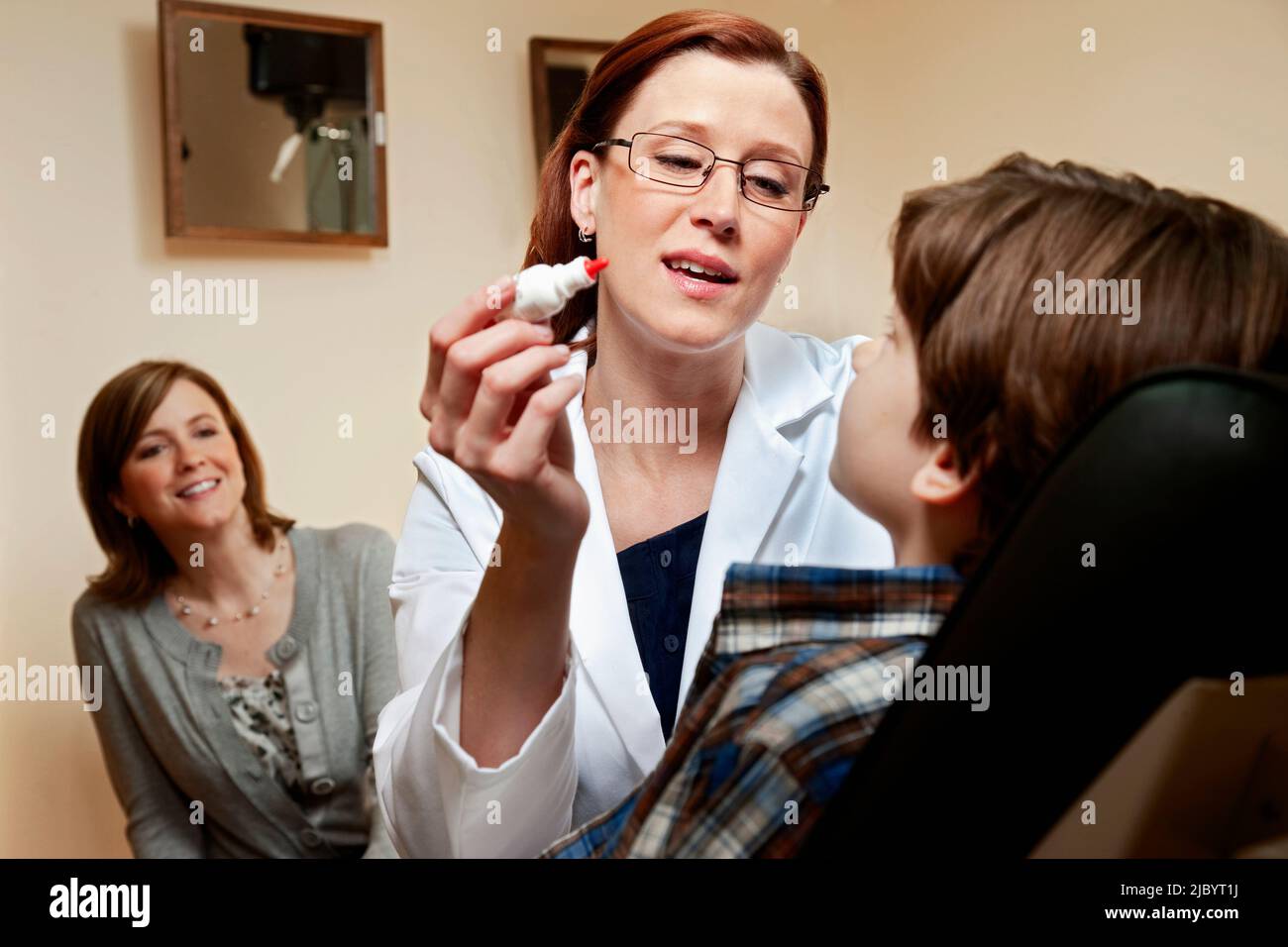 Optician putting drops into patient's eyes Stock Photo - Alamy