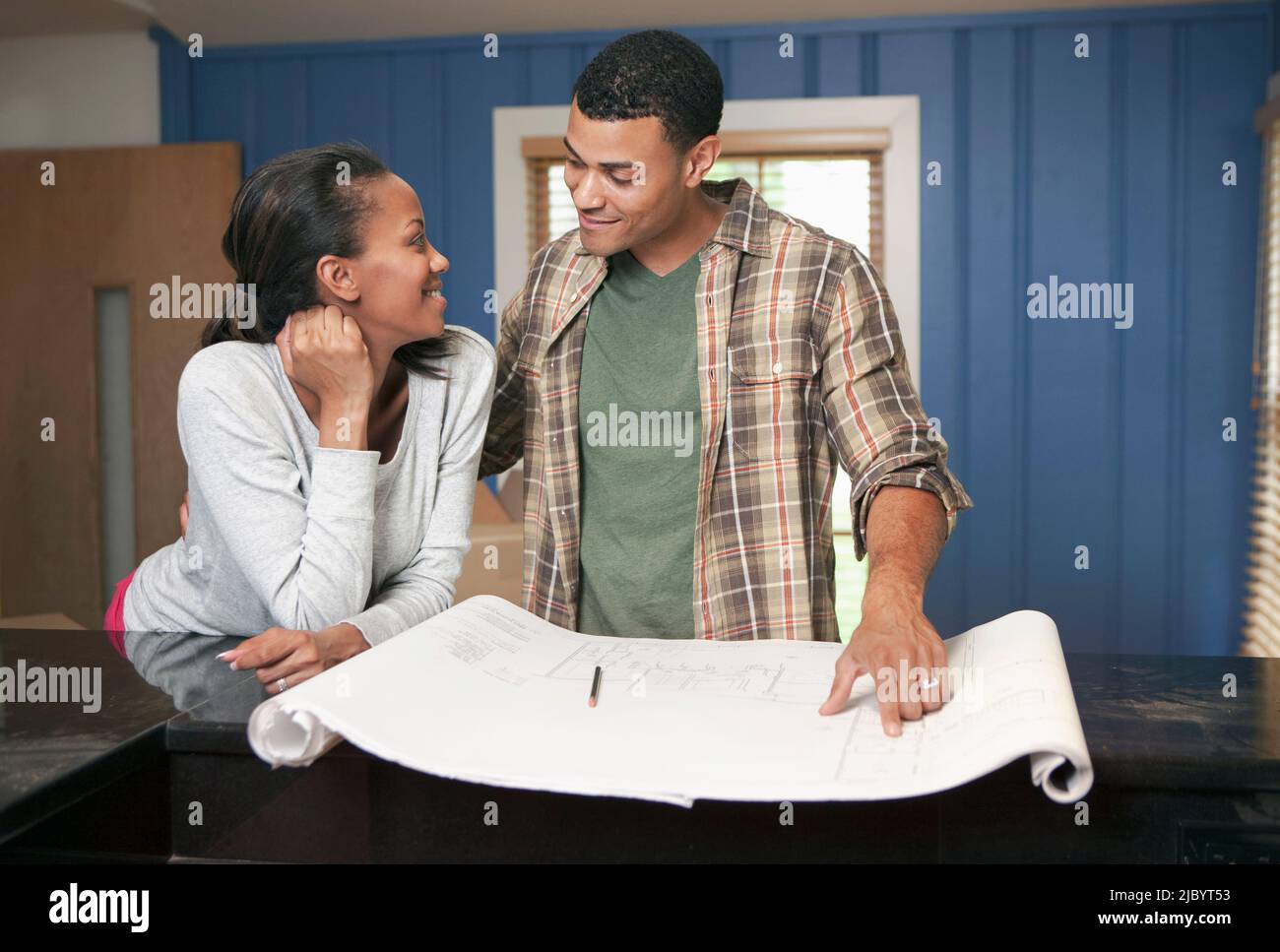 Couple looking at blueprints together Stock Photo - Alamy