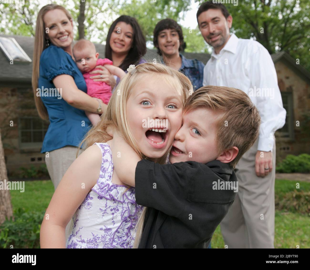 Family standing in front yard together Stock Photo - Alamy