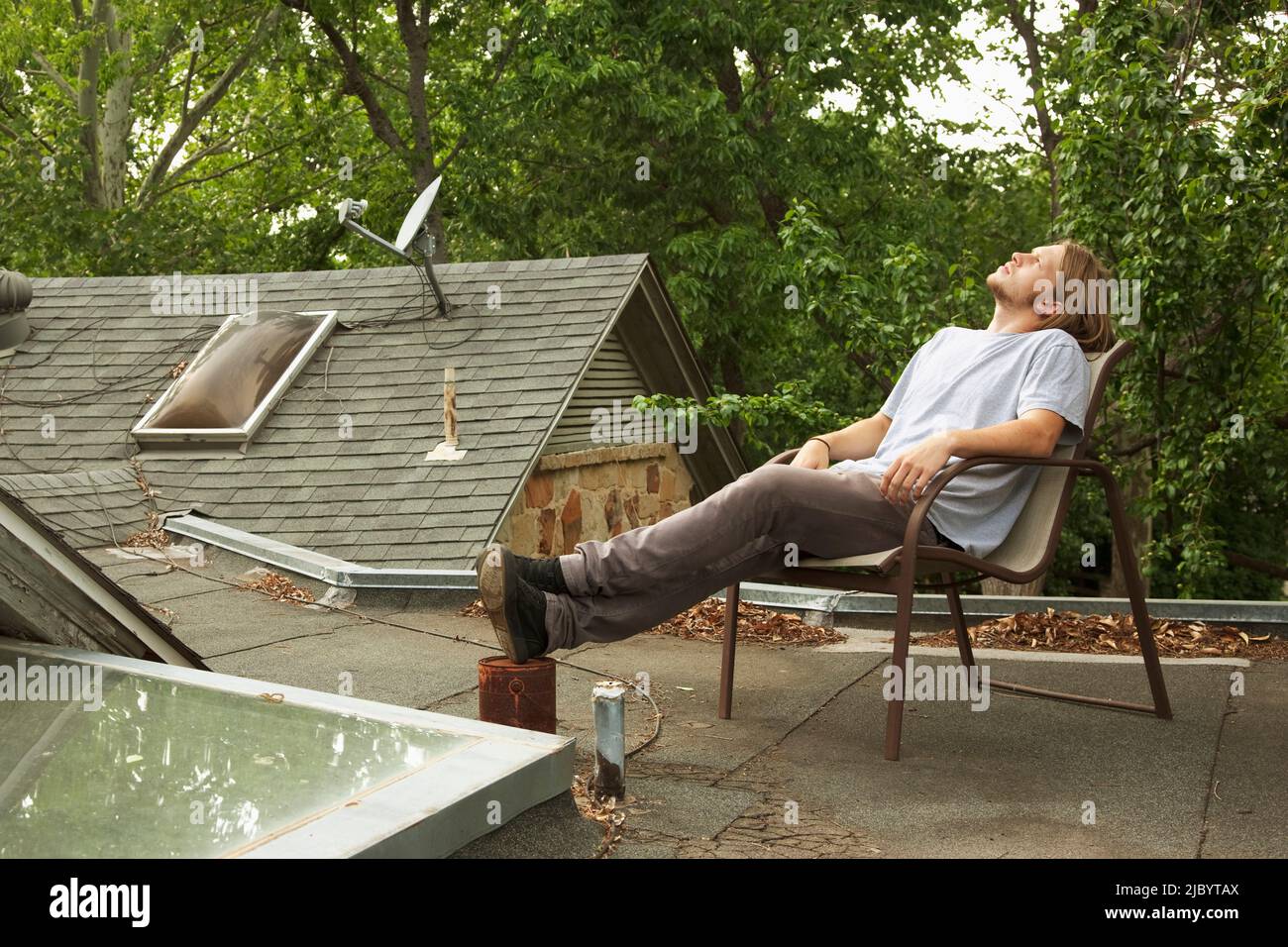 Man relaxing on roof Stock Photo - Alamy