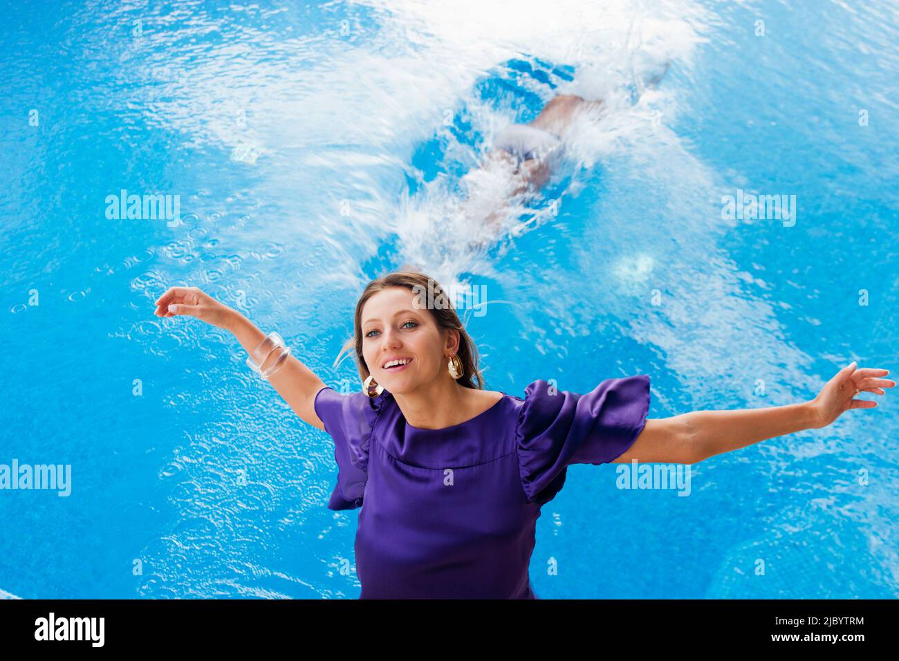 Woman standing by splashing pool Stock Photo - Alamy