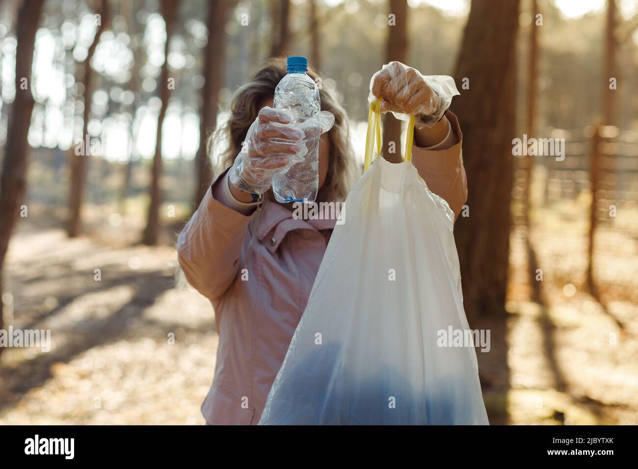 Woman volunteer and assistant helping cleaning forest from plastic ...