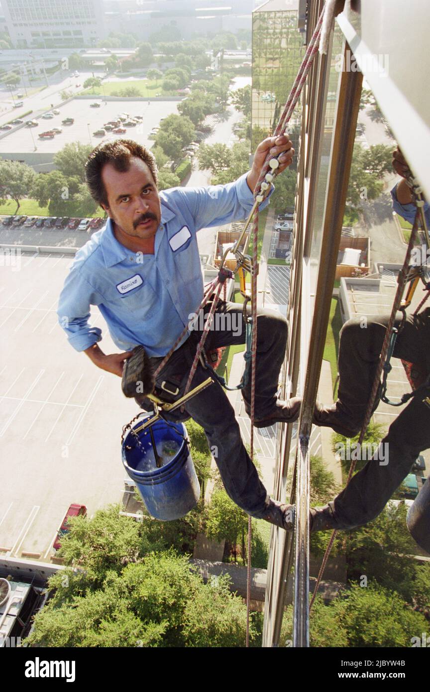 Hispanic window washer on side of building Stock Photo - Alamy
