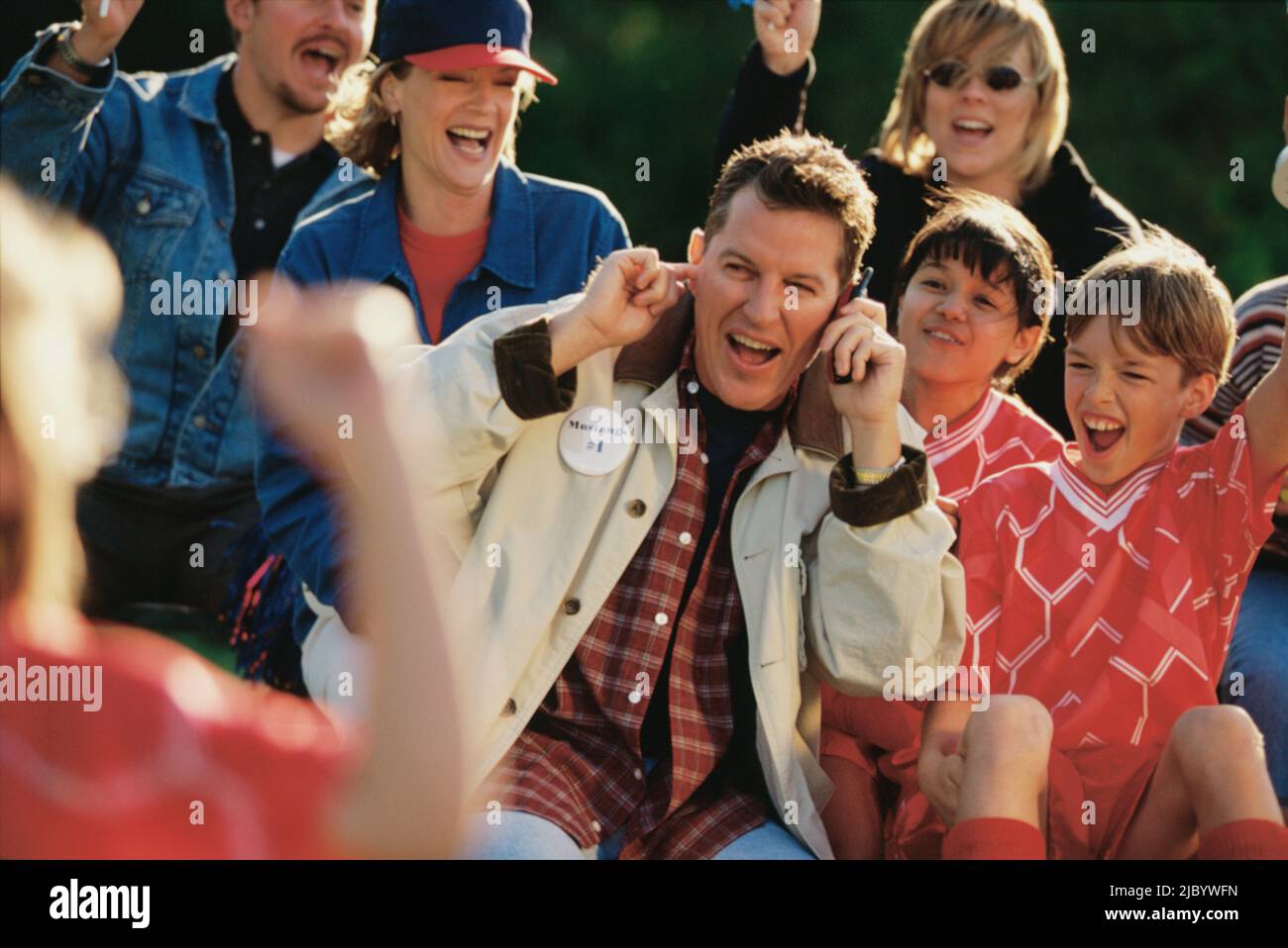 Parents and children in athletic gear cheering Stock Photo - Alamy