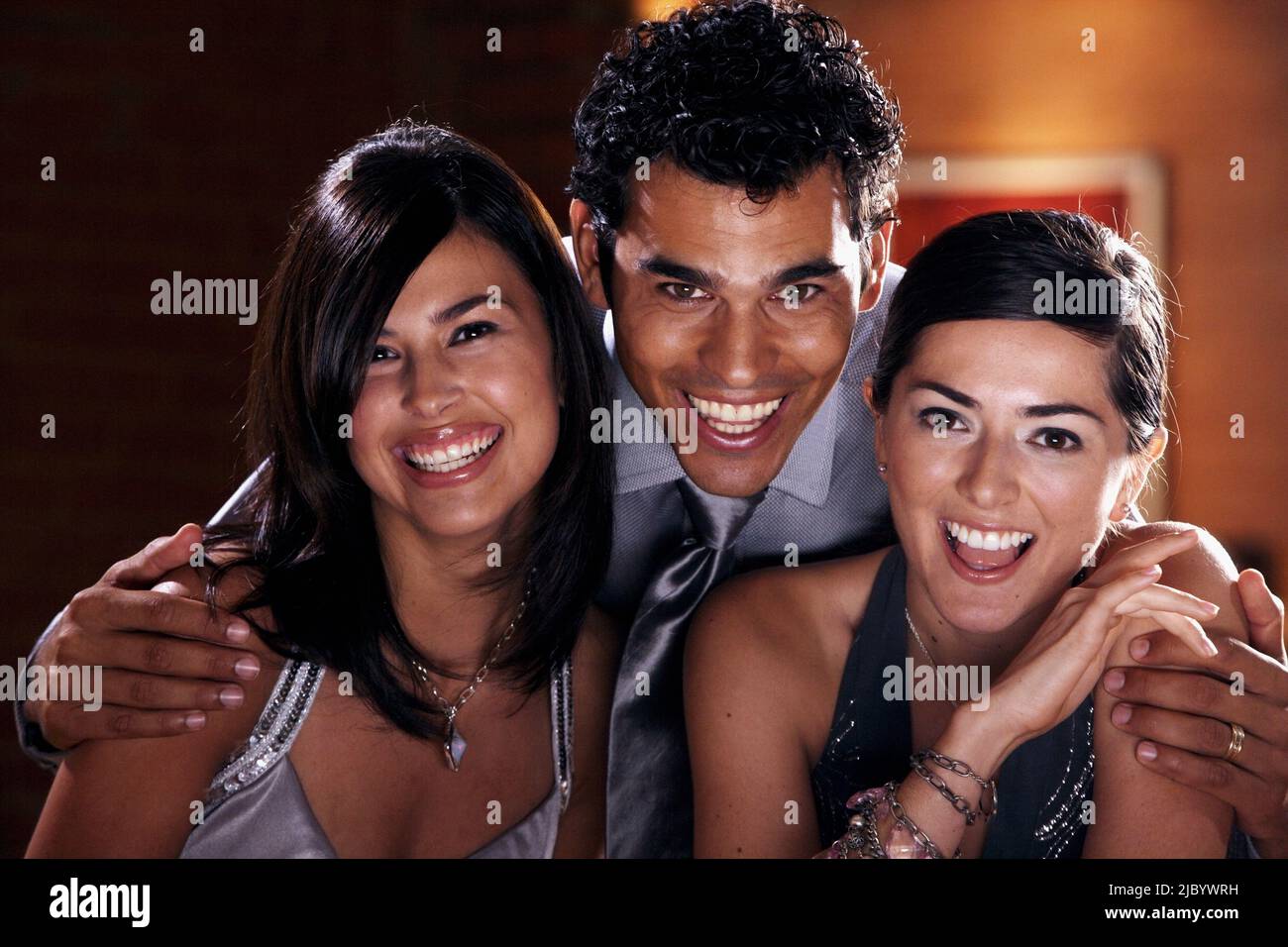 Hispanic friends dressed for a night out and hugging Stock Photo - Alamy