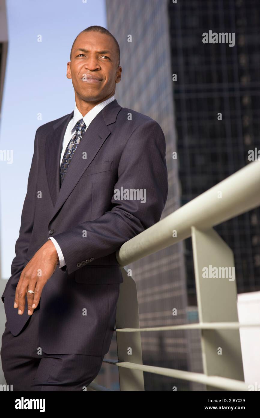 African businessman leaning on railing outdoors Stock Photo - Alamy