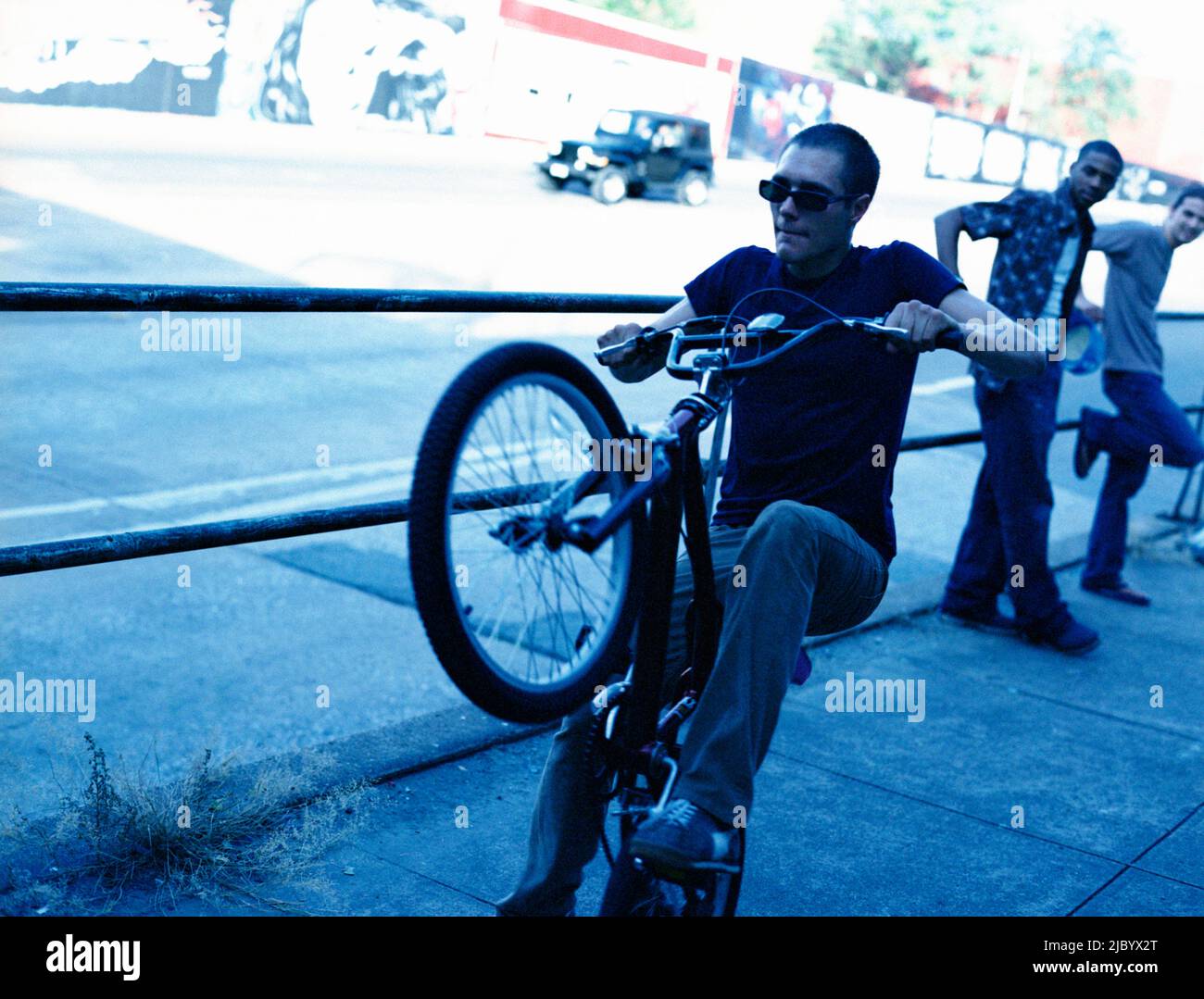 Young man doing stunt on bicycle Stock Photo - Alamy
