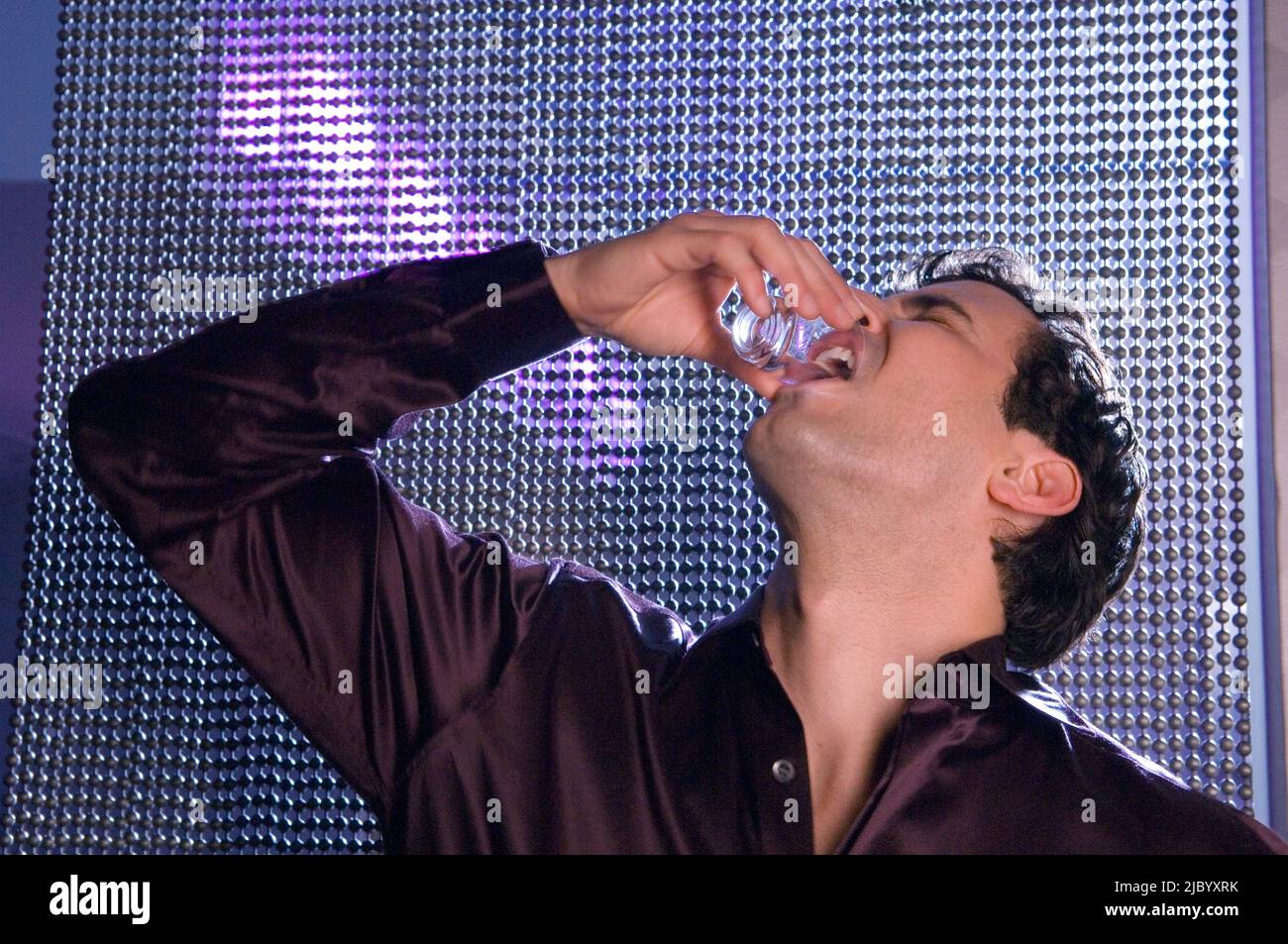 Hispanic man drinking alcohol shot Stock Photo - Alamy