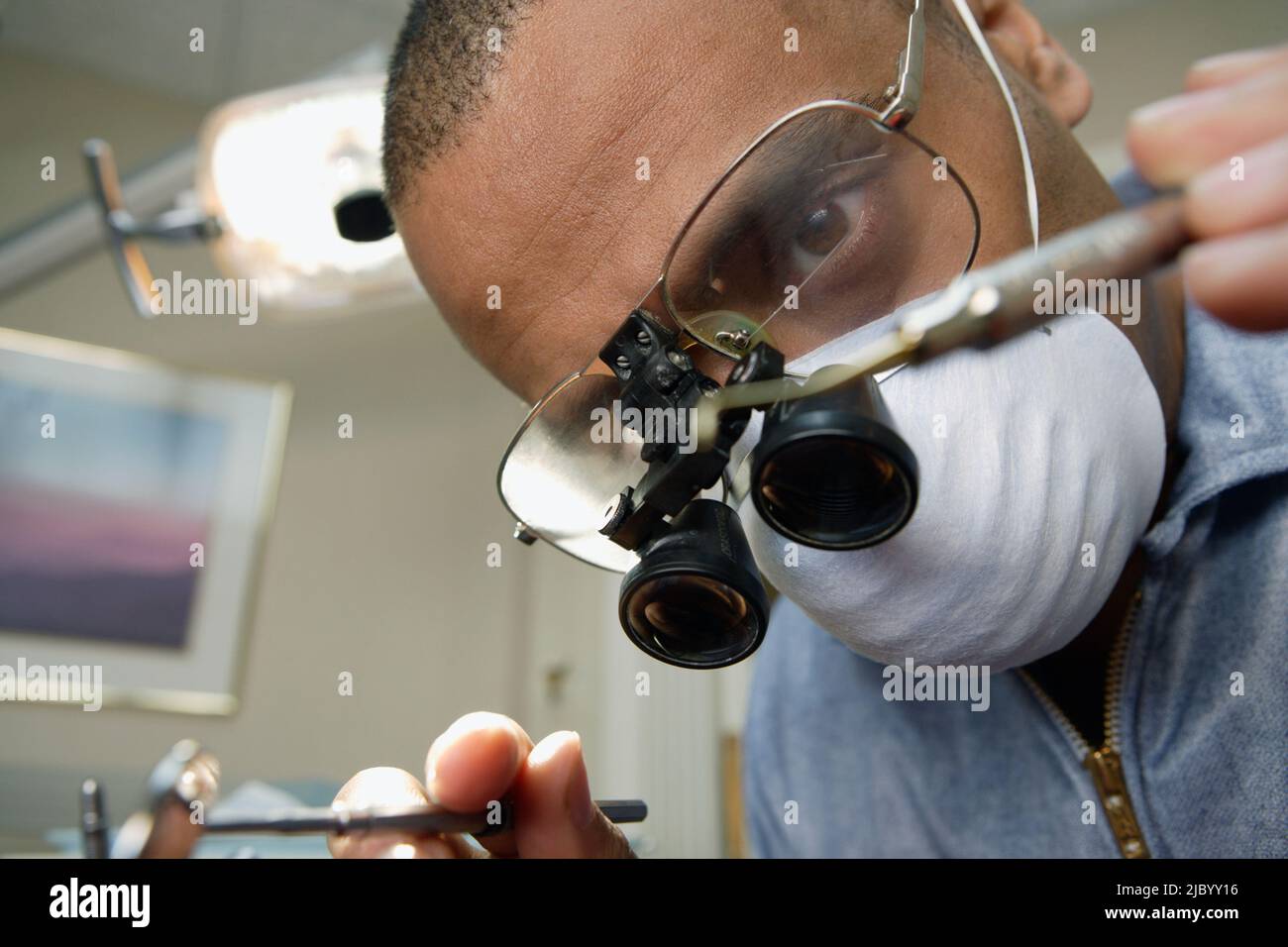 Indian male dentist performing exam Stock Photo - Alamy