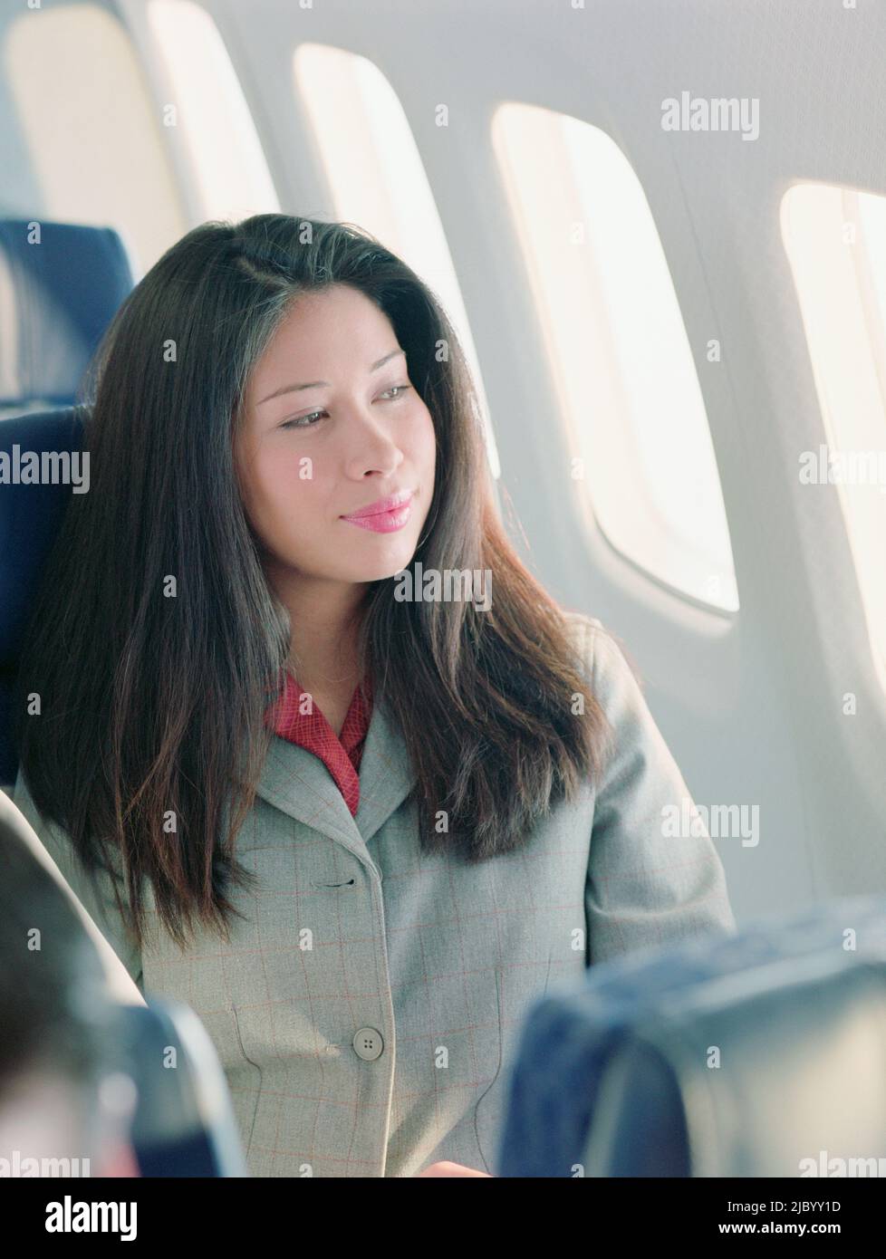 Asian woman looking out airplane window Stock Photo - Alamy