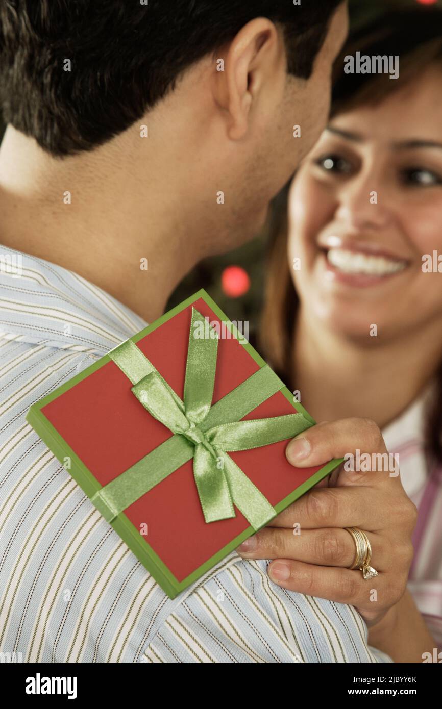Hispanic couple hugging with gift Stock Photo - Alamy