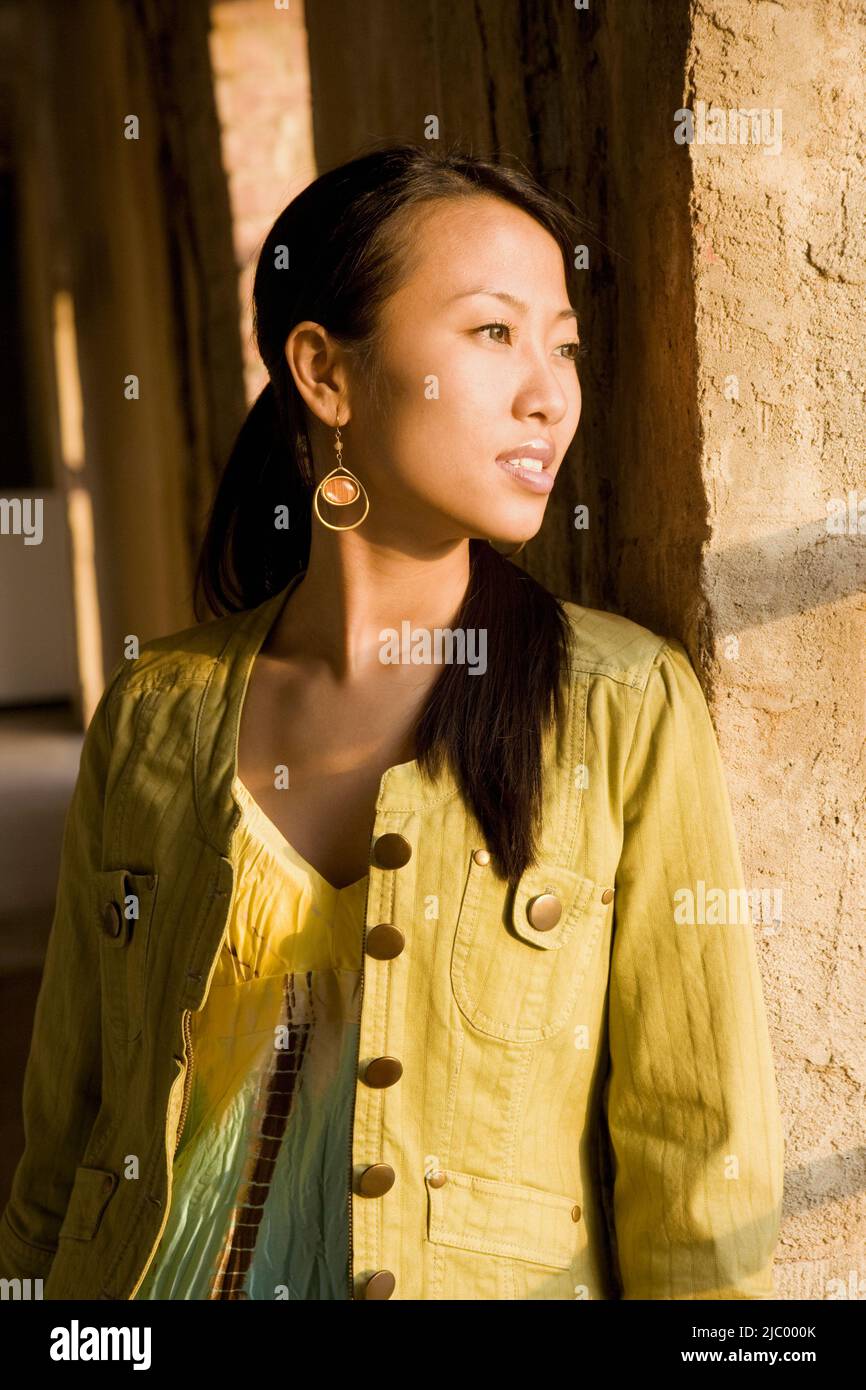 Asian woman leaning on column Stock Photo - Alamy