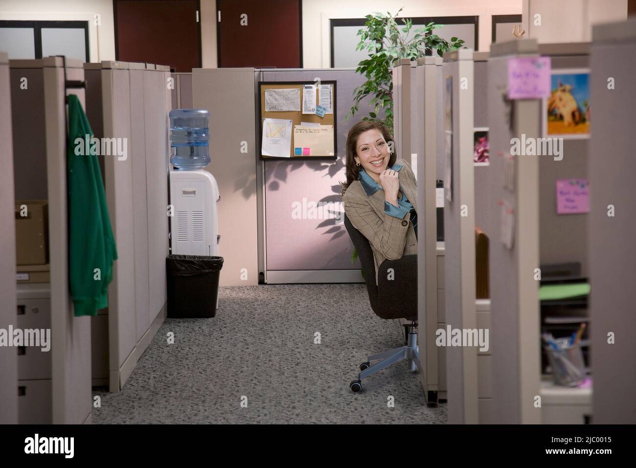 Hispanic businesswoman looking out from cubicle Stock Photo - Alamy