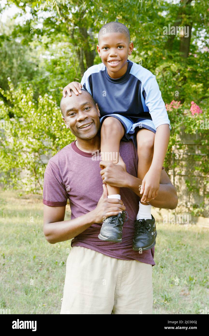 Young boy sitting on father's shoulder Stock Photo - Alamy