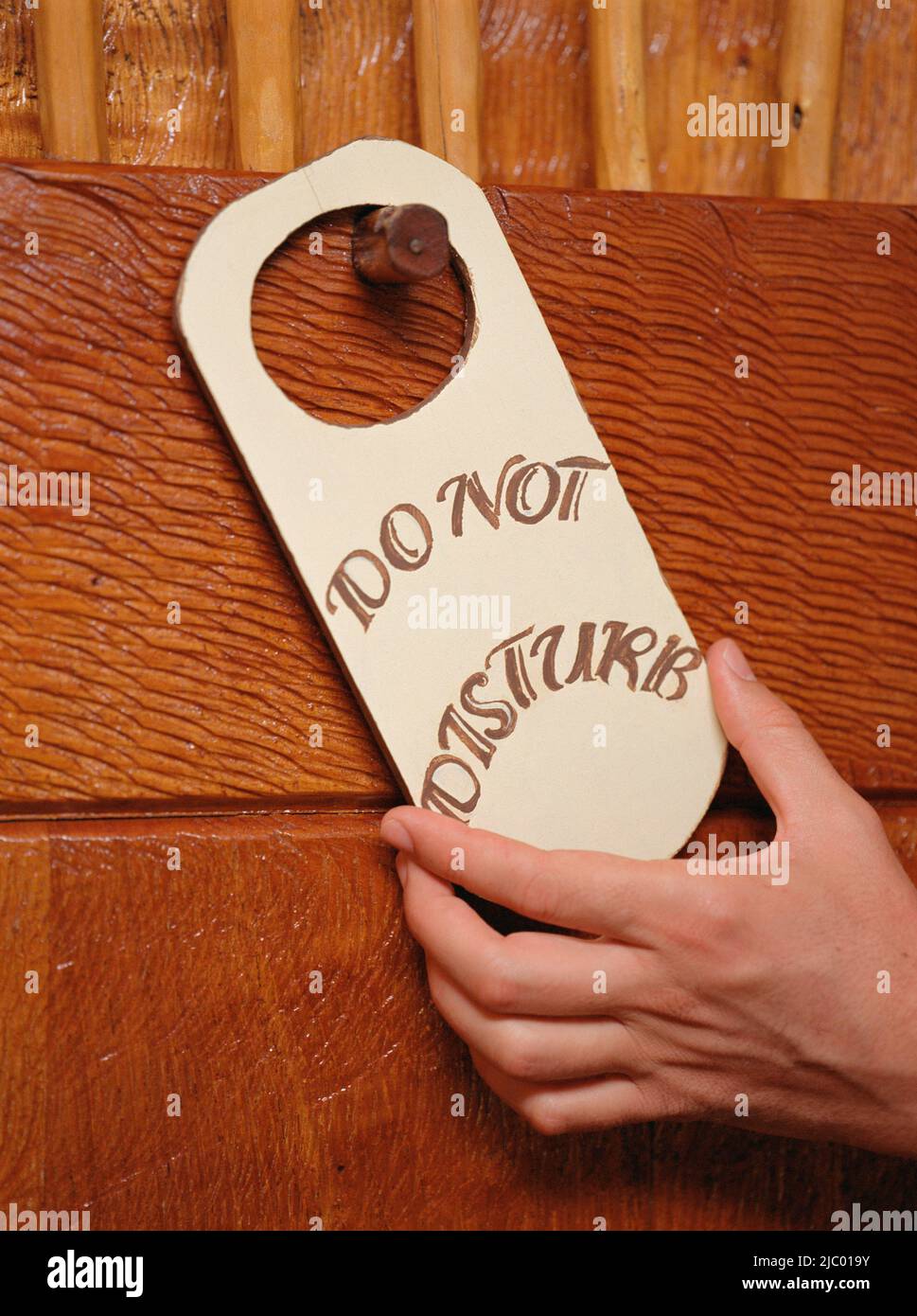 Hand putting Do Not Disturb sign on doorknob Stock Photo - Alamy