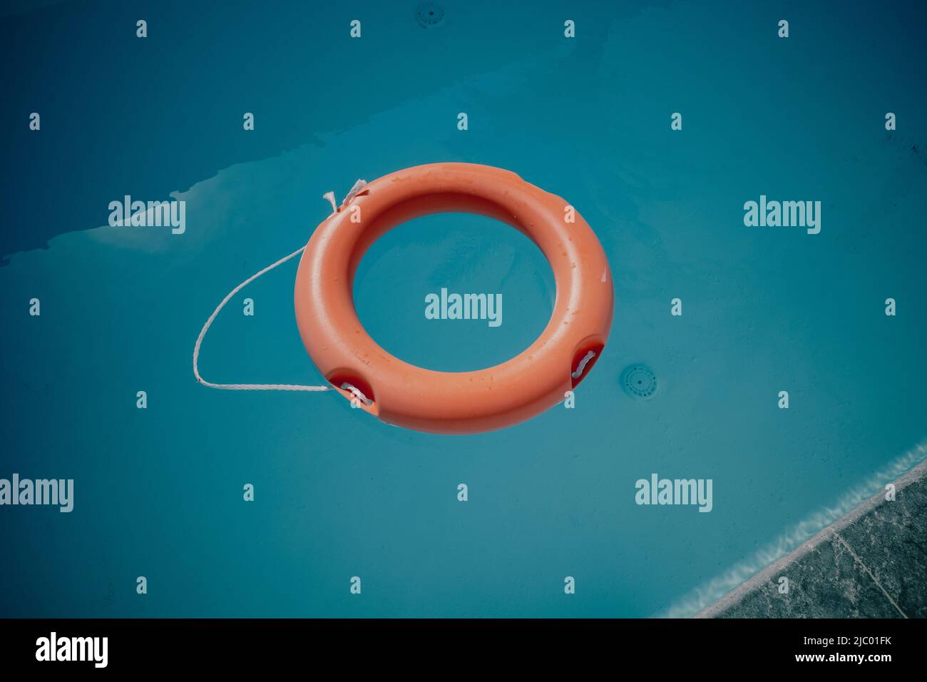 in the blue water of a swimming pool floats a red life ring Stock Photo ...