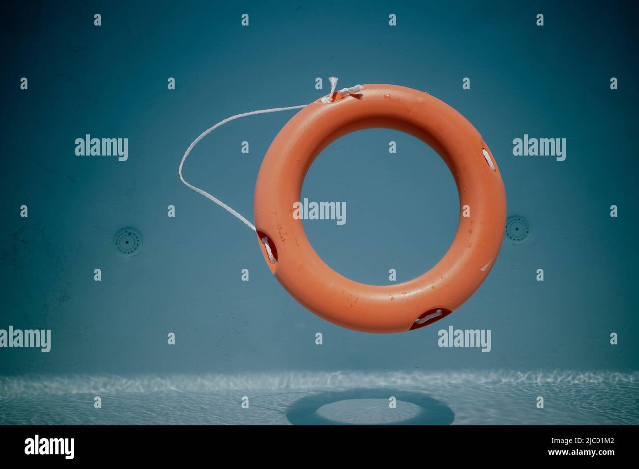in the blue water of a swimming pool floats a red life ring Stock Photo ...