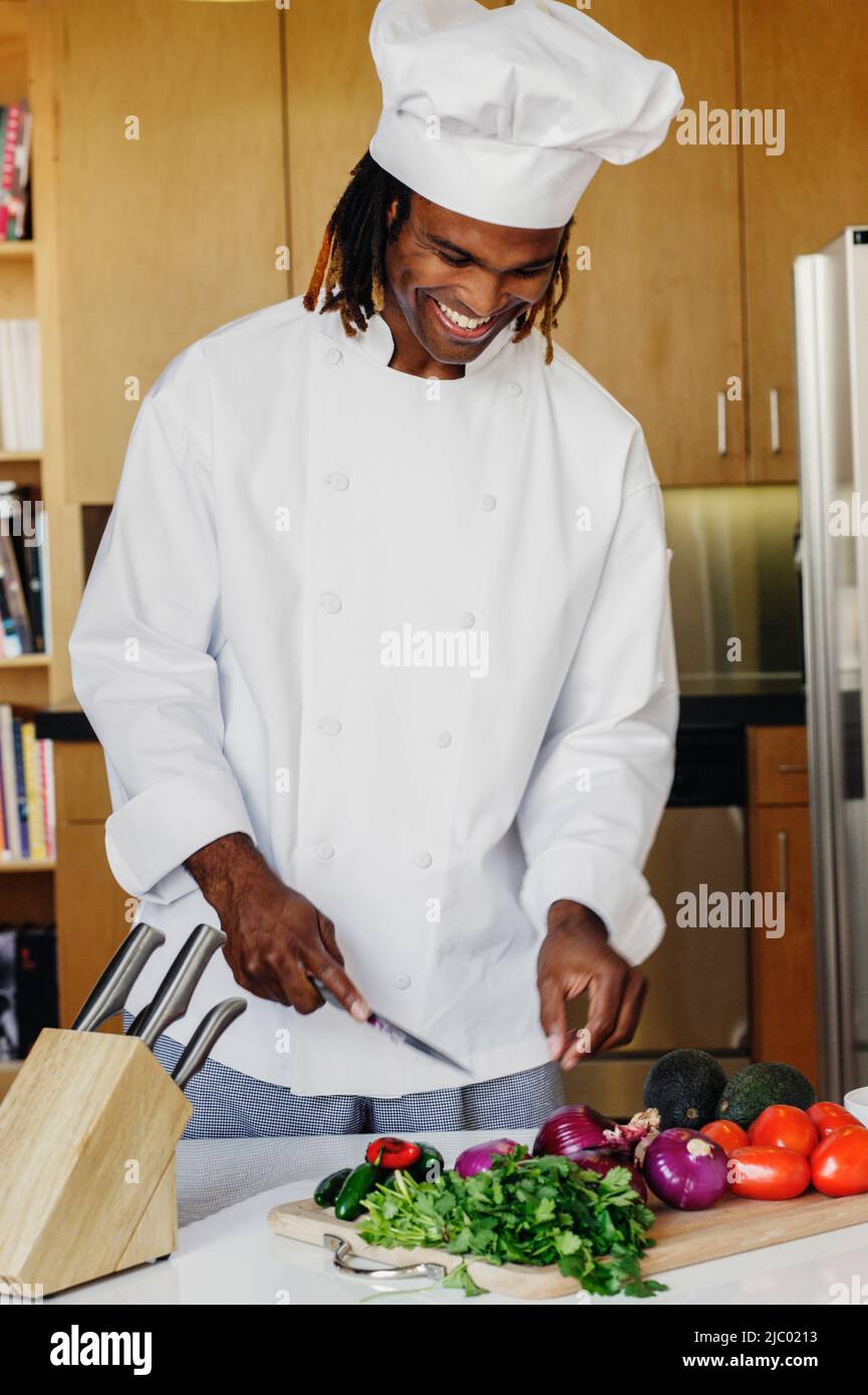 Male chef cutting up vegetables Stock Photo - Alamy