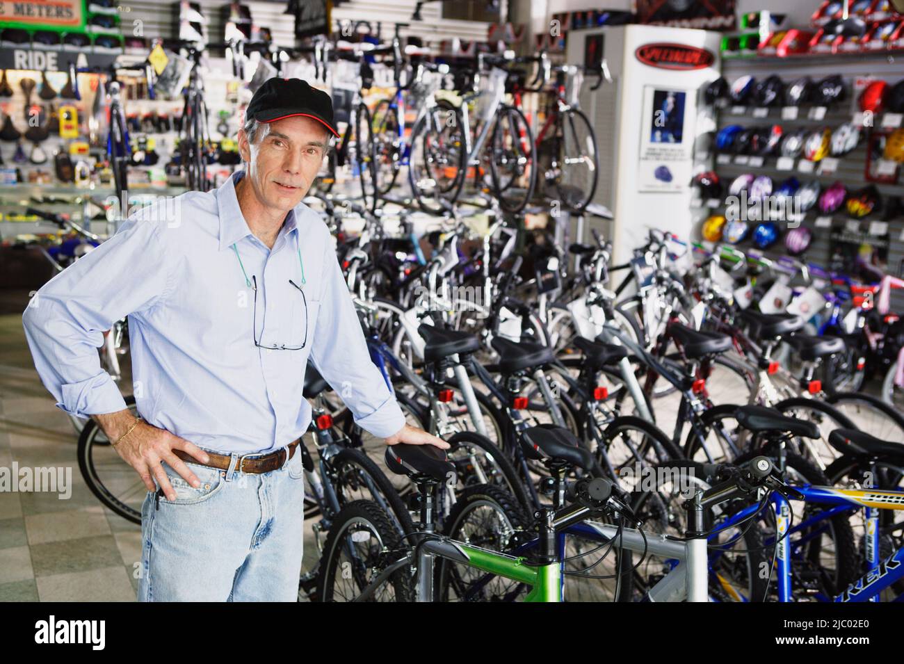 Portrait of man standing in bike shop Stock Photo - Alamy