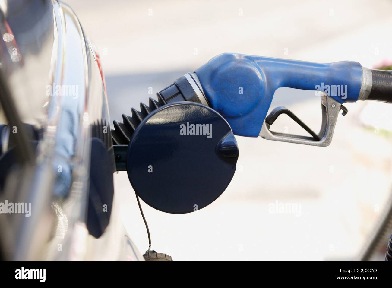 Gas pump inserted into car Stock Photo - Alamy