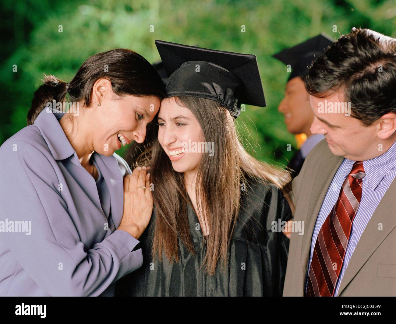 Mother and father hugging graduate daughter Stock Photo - Alamy