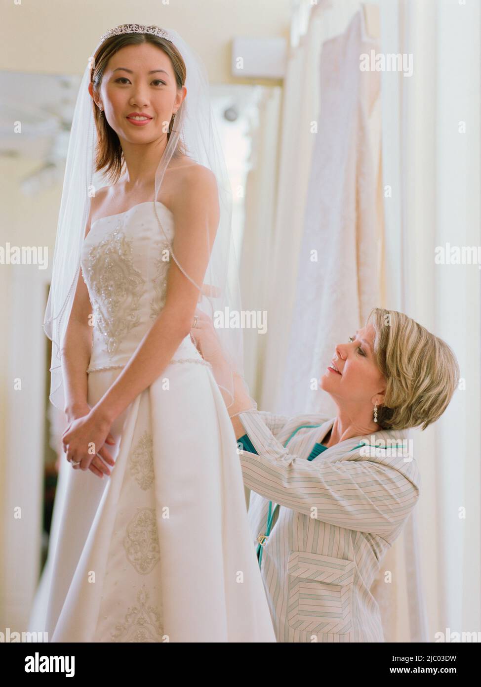 Young bride being fitted in her dress Stock Photo - Alamy