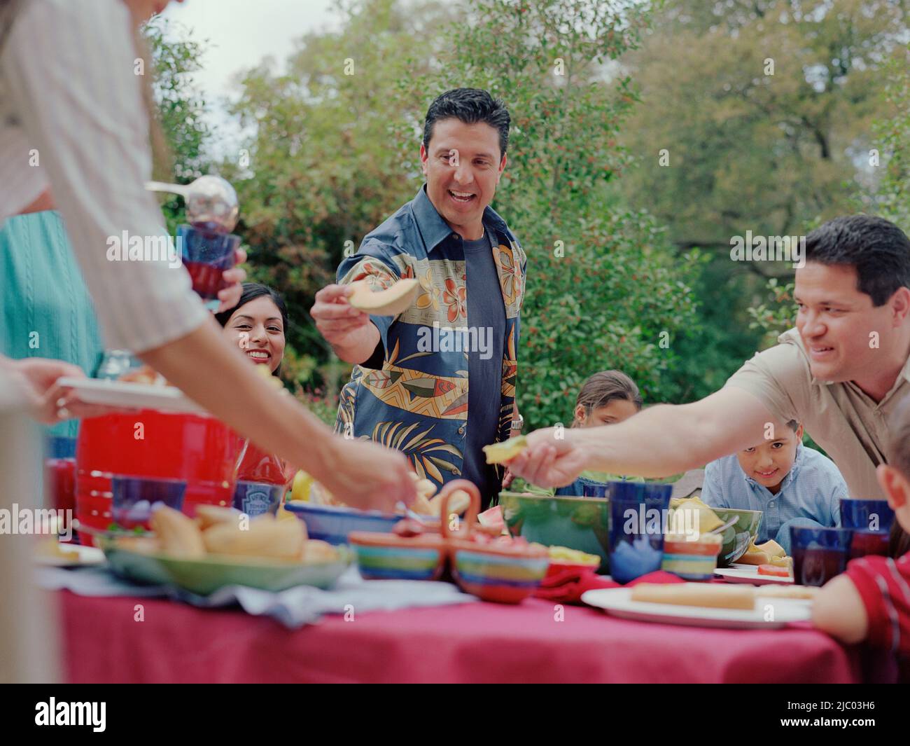 People reaching for food at a barbecue Stock Photo - Alamy
