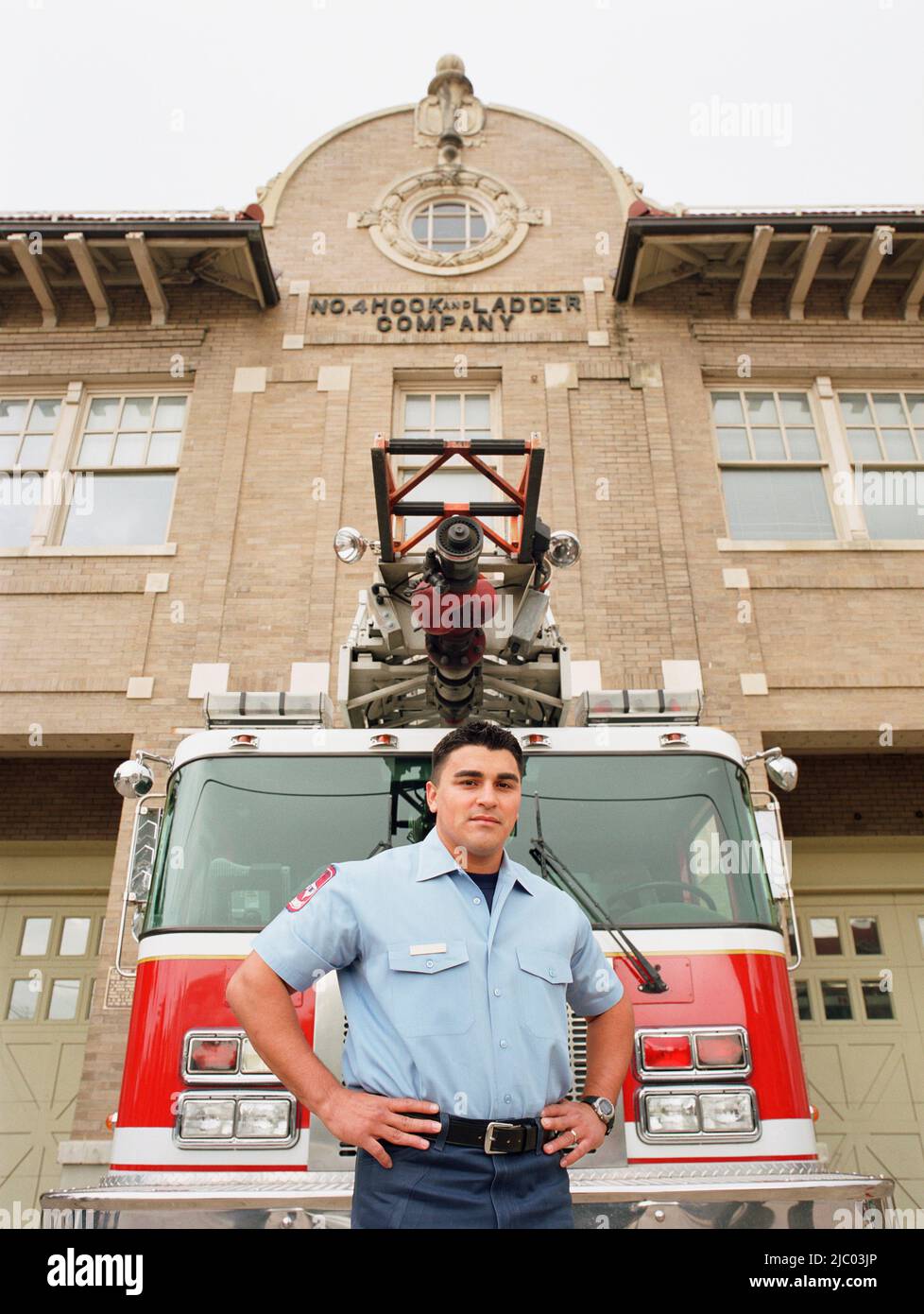 Fireman posing for the camera by fire engine Stock Photo - Alamy
