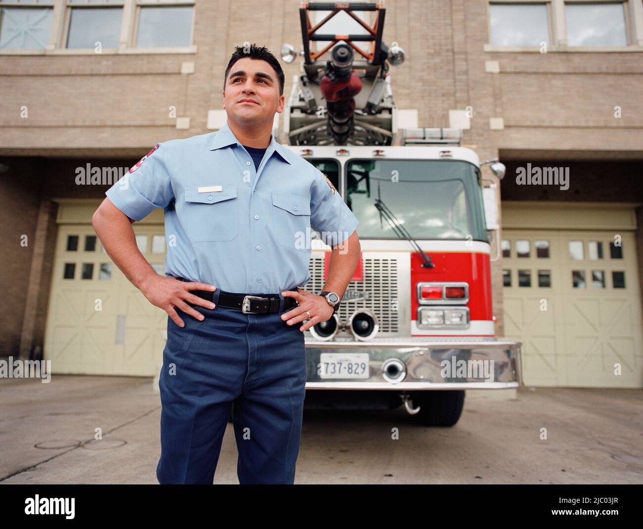 Fireman posing for the camera by fire engine Stock Photo - Alamy