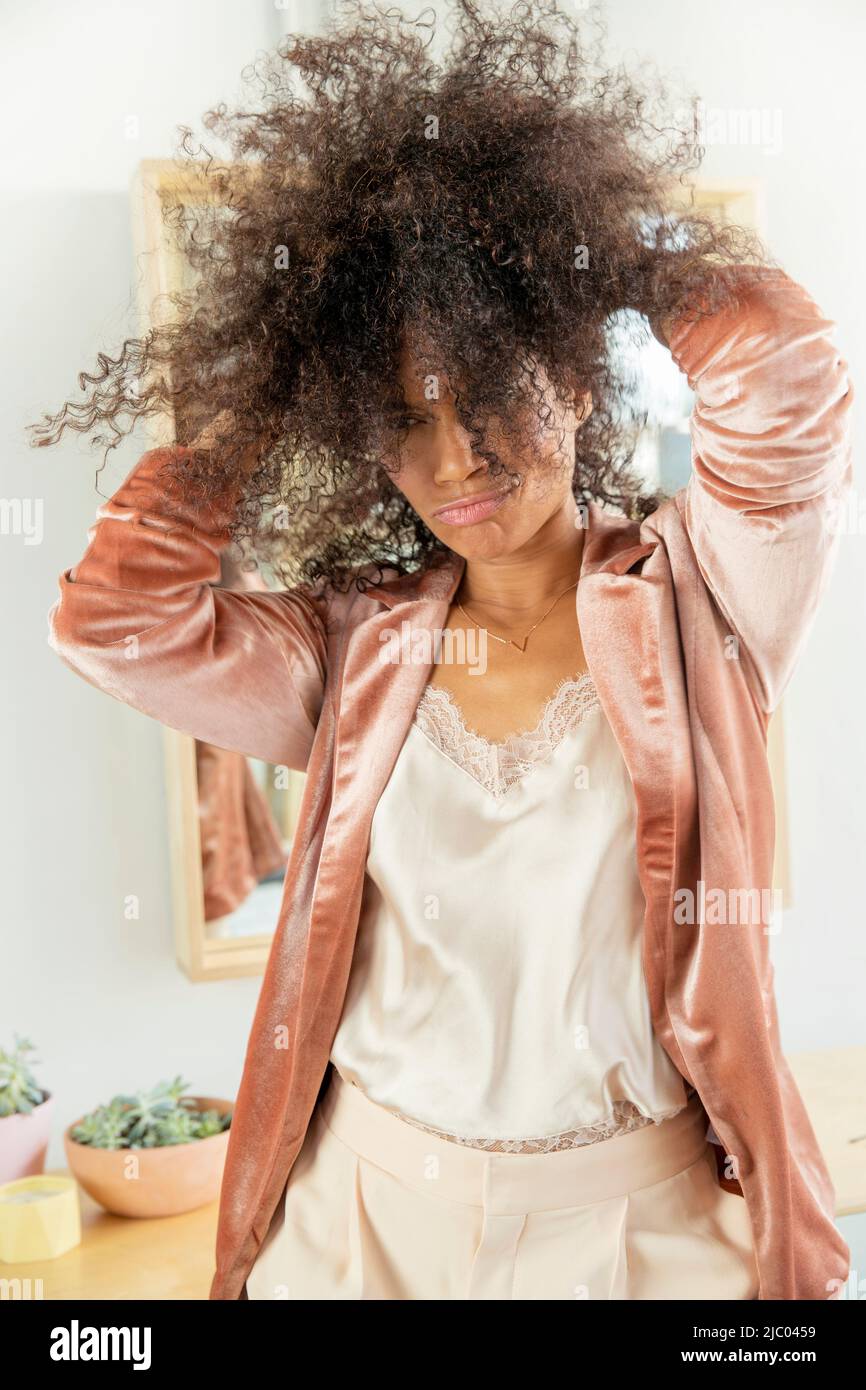 Middle-aged woman runs her hands through her hair and brings it in front of her face Stock Photo ...