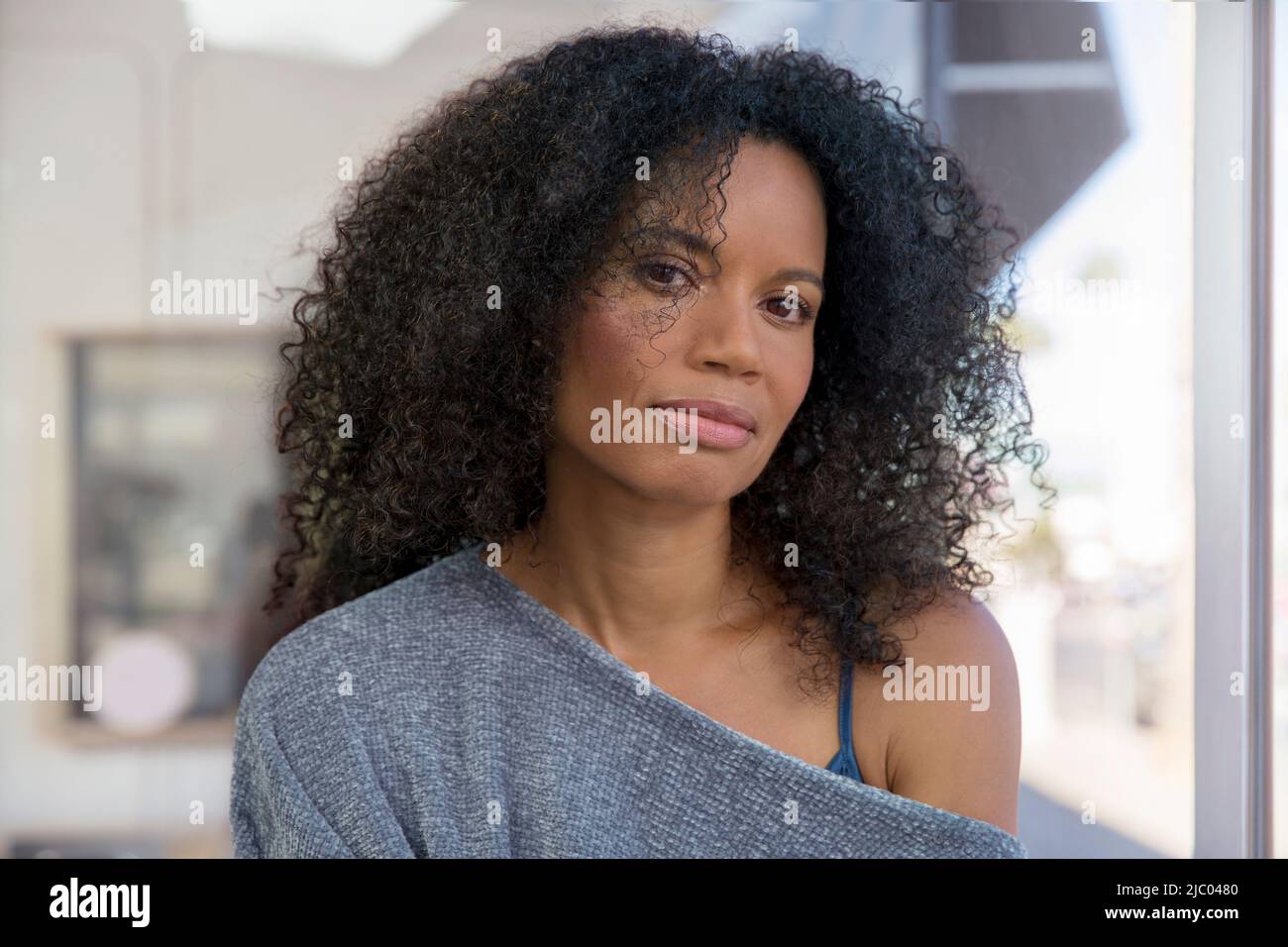 Mixed race, middle-aged woman with natural hair looking at camera Stock Photo - Alamy