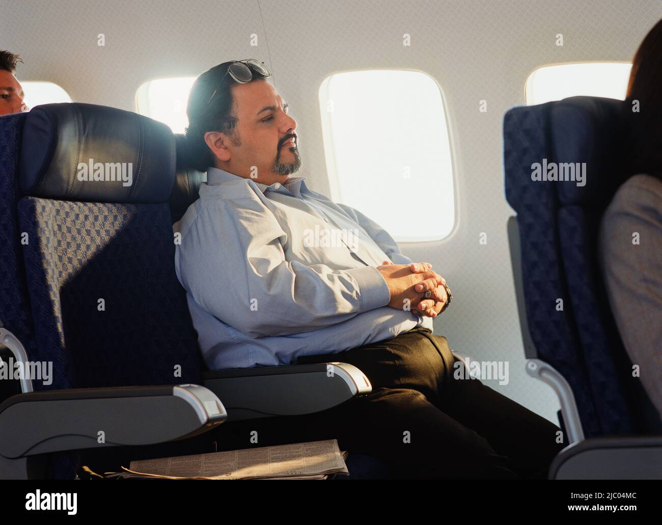 Overweight man resting on airplane Stock Photo - Alamy