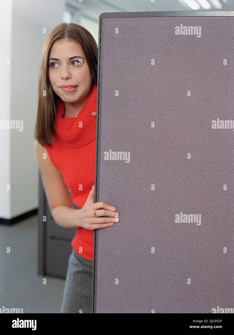 Businesswoman peeking out from behind cubicle wall Stock Photo - Alamy
