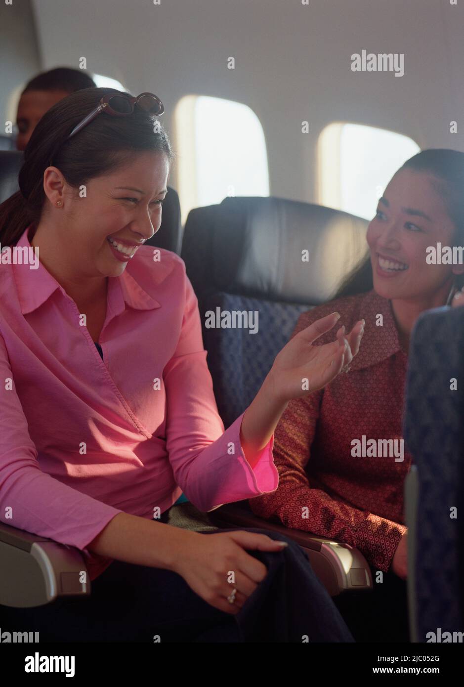 Young women talking on airplane Stock Photo - Alamy