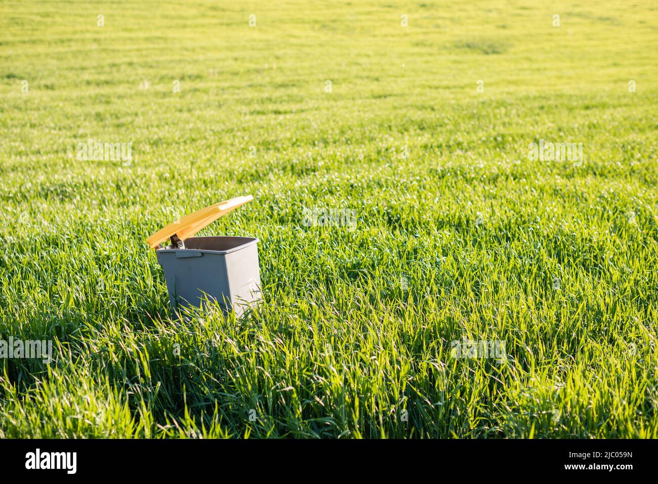 Plastic garbage container stands in the middle of a green field Stock ...