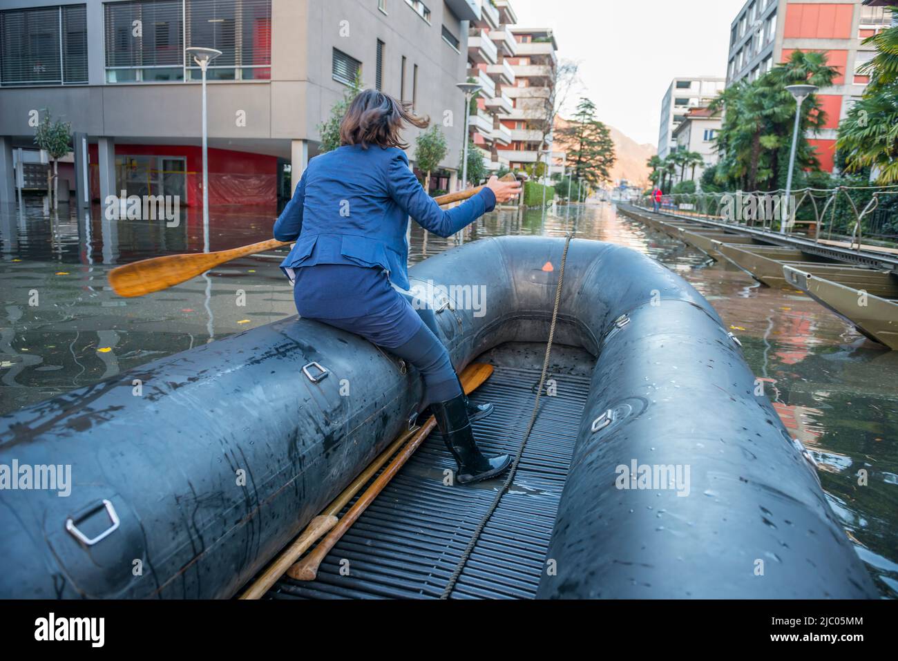 Woman Rowing a Rescue Boat in City of Locarno on Flooding Street in ...