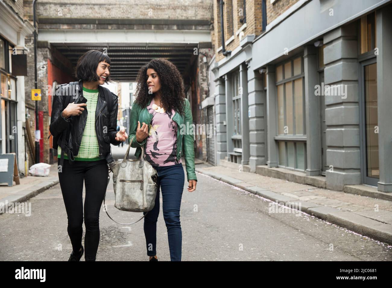 Two women walking and talking on the streets of London Stock Photo - Alamy