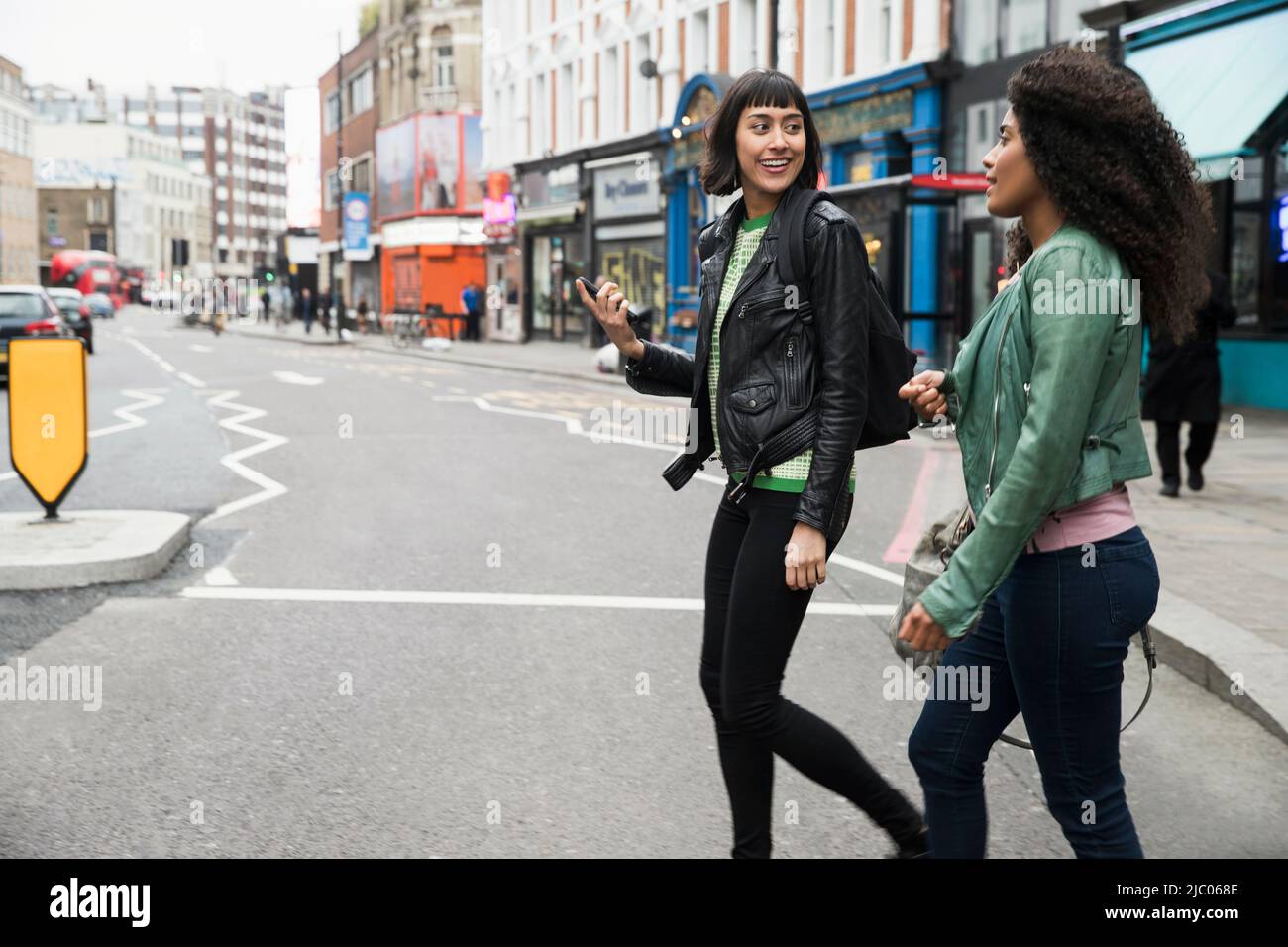 Two women walking and talking on the streets of London Stock Photo - Alamy