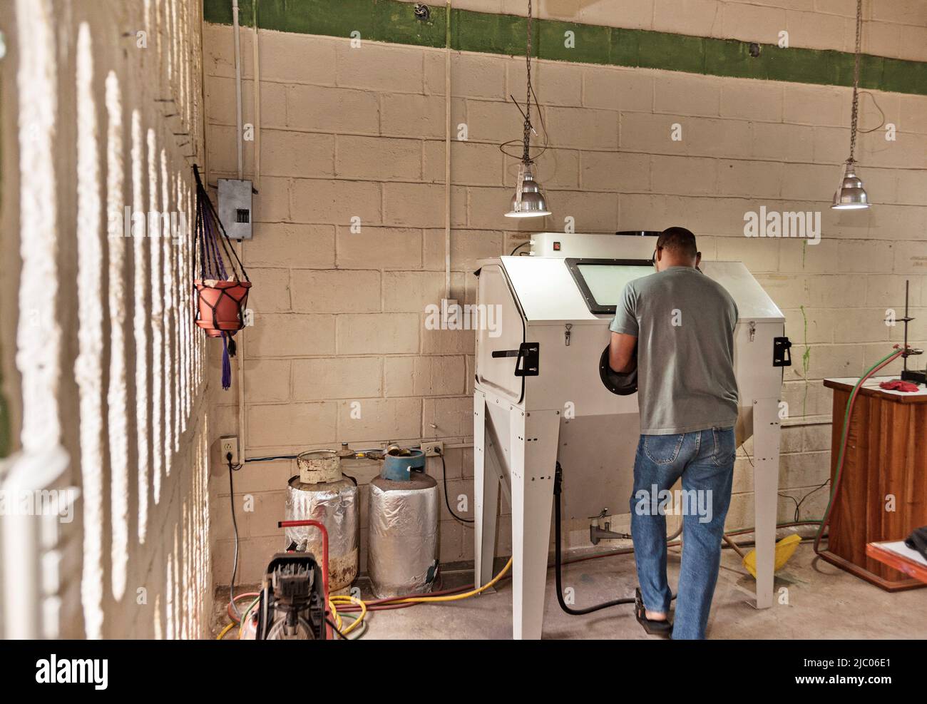 Ecuador, Galapagos Islands, Man sandblasting glass to make souvenir ...