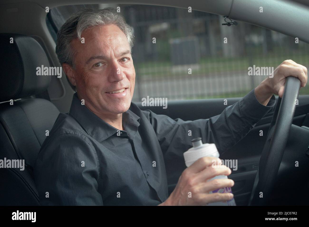 Man drinking water while driving a car Stock Photo - Alamy