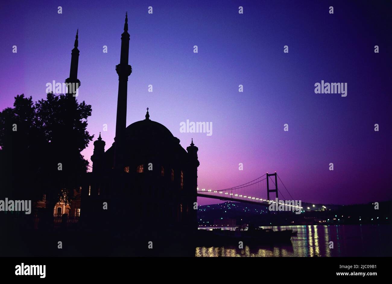 Silhouette of a mosque with a bridge lit up in the background, Ortakoy ...