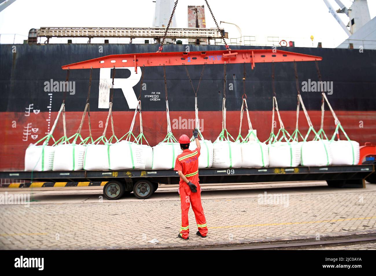 QINGDAO, CHINA - JUNE 9, 2022 - Dockworkers lift export goods at a ...